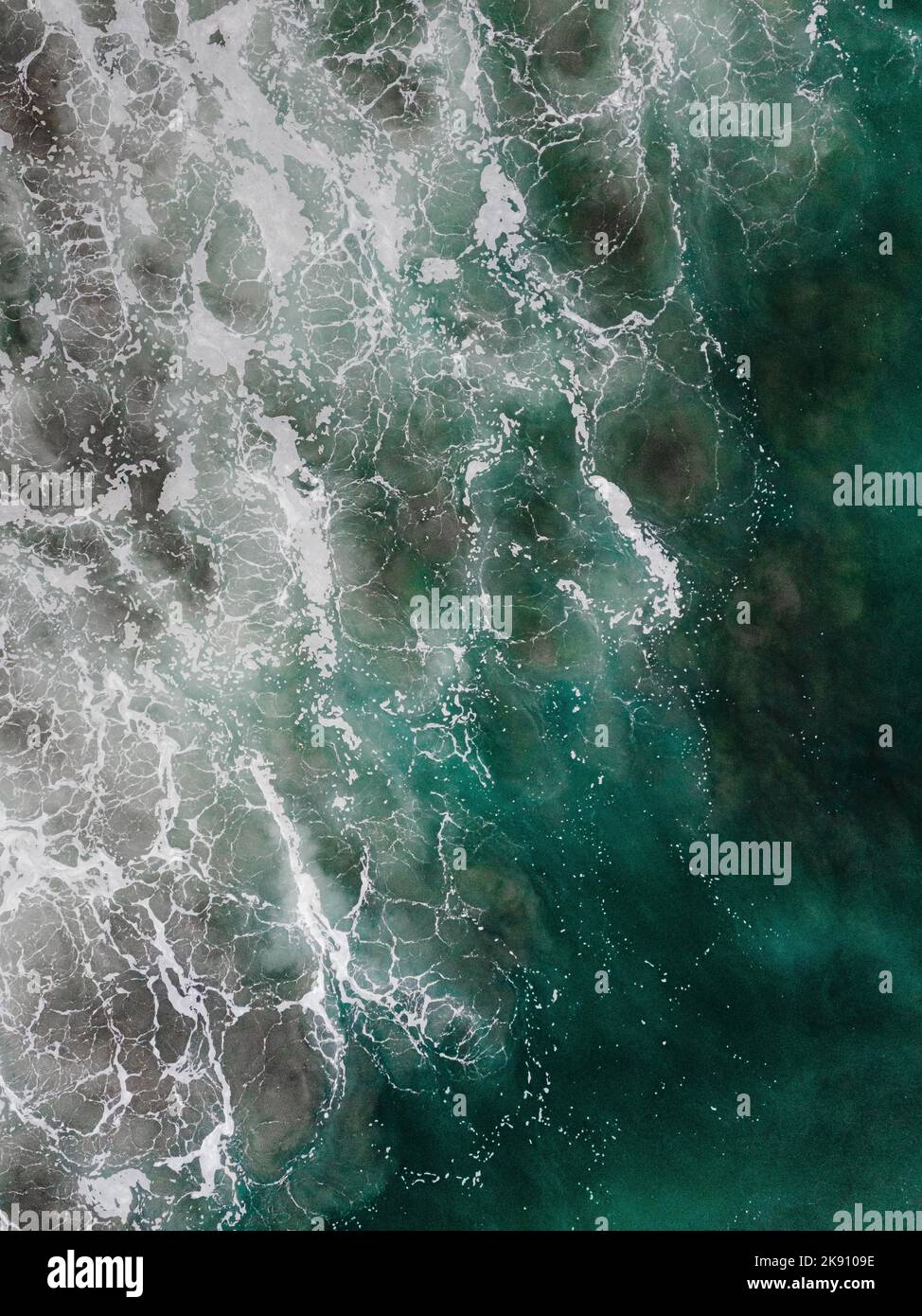 A vertical closeup of sea foam poster, blue waves with a long exposure ...