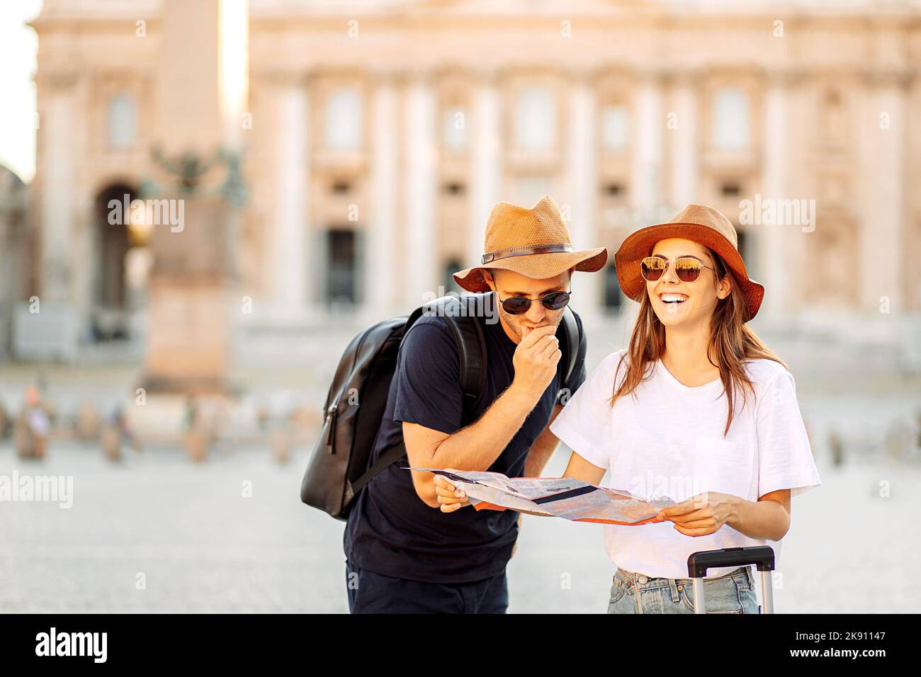 Happy tourists looking at a map and choose a hotel. Couple of tourists ...