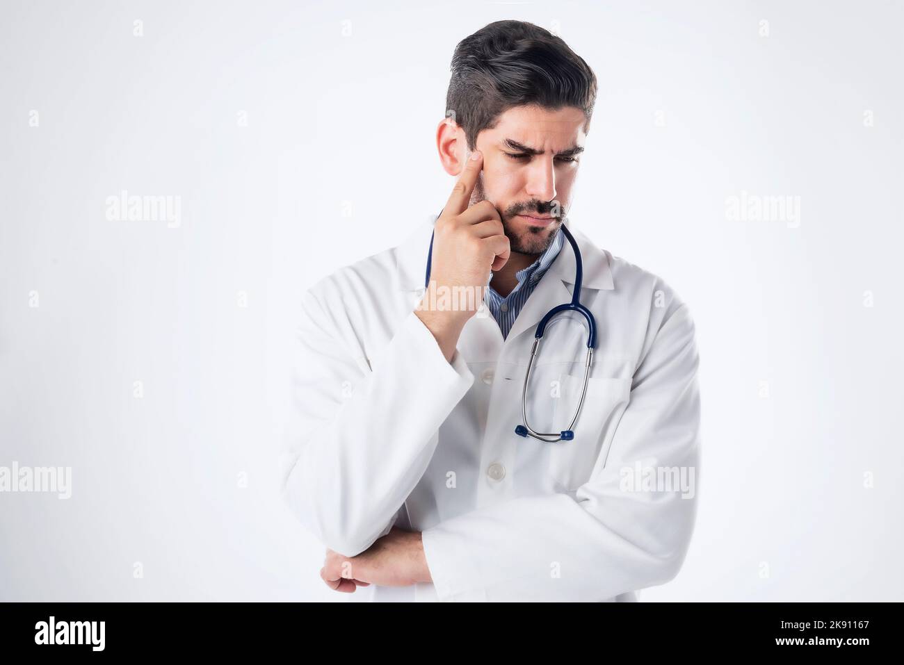 Portrait of male doctor deep in thought while standing at isolated ...