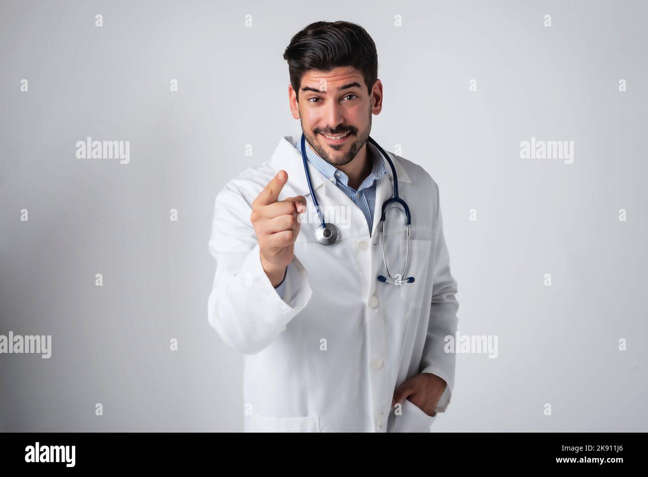 Studio shot of a male doctor pointing at you on while standing at ...