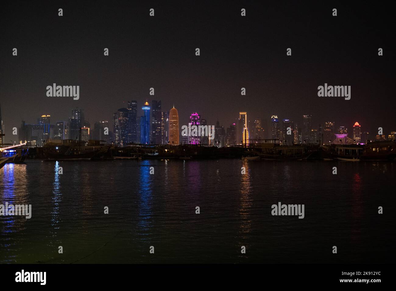 Slightly hazy Doha skyline at night, viewed across the water, from the ...