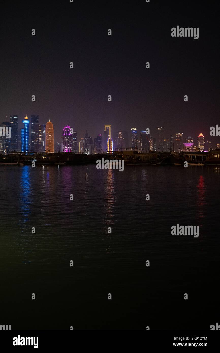 Slightly hazy Doha skyline at night, viewed across the water, from the ...