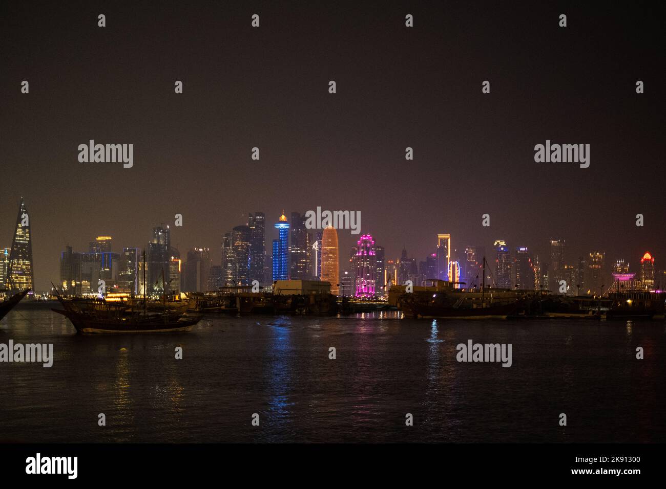 Slightly hazy Doha skyline at night, viewed across the water, from the ...