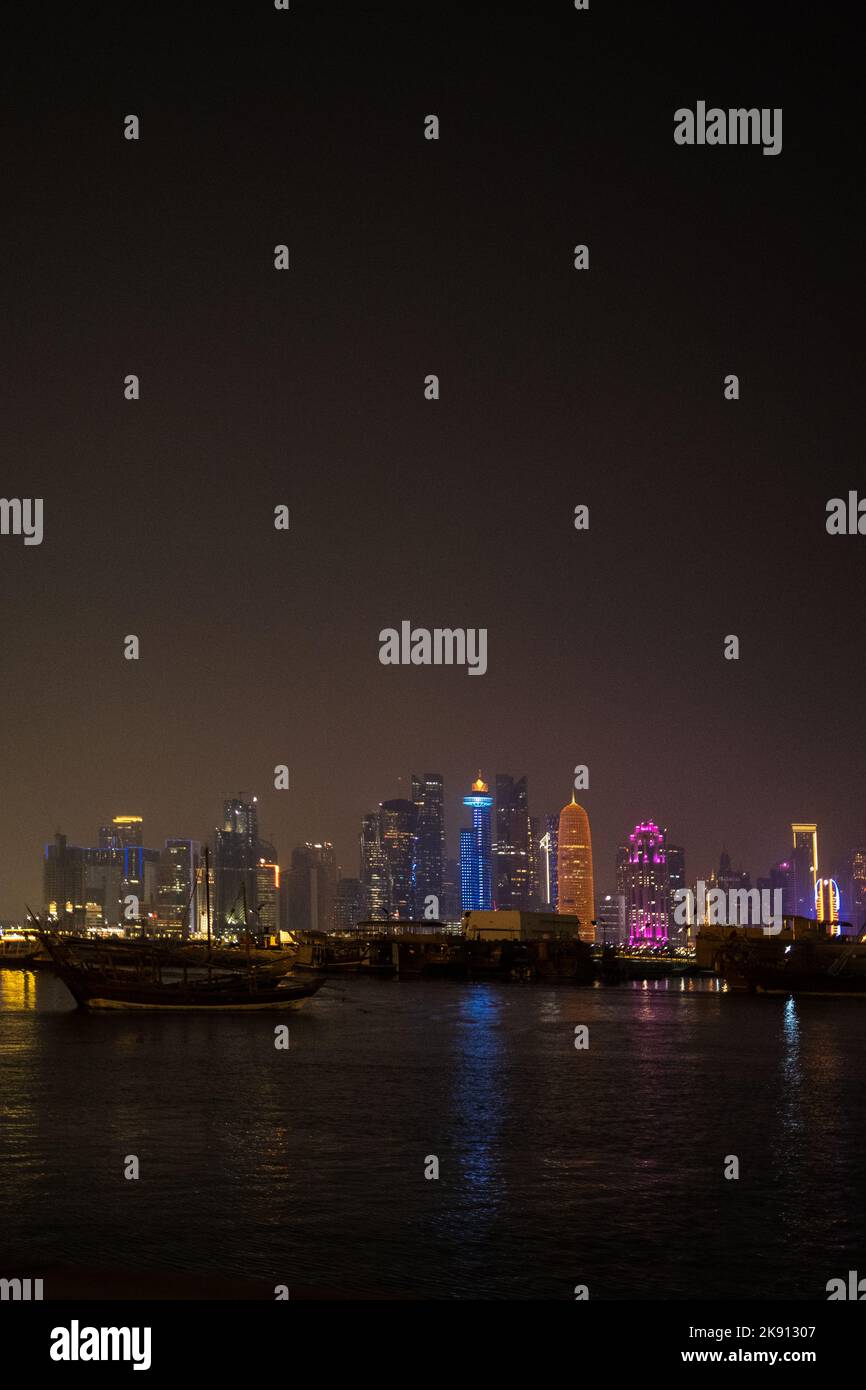 Slightly hazy Doha skyline at night, viewed across the water, from the ...