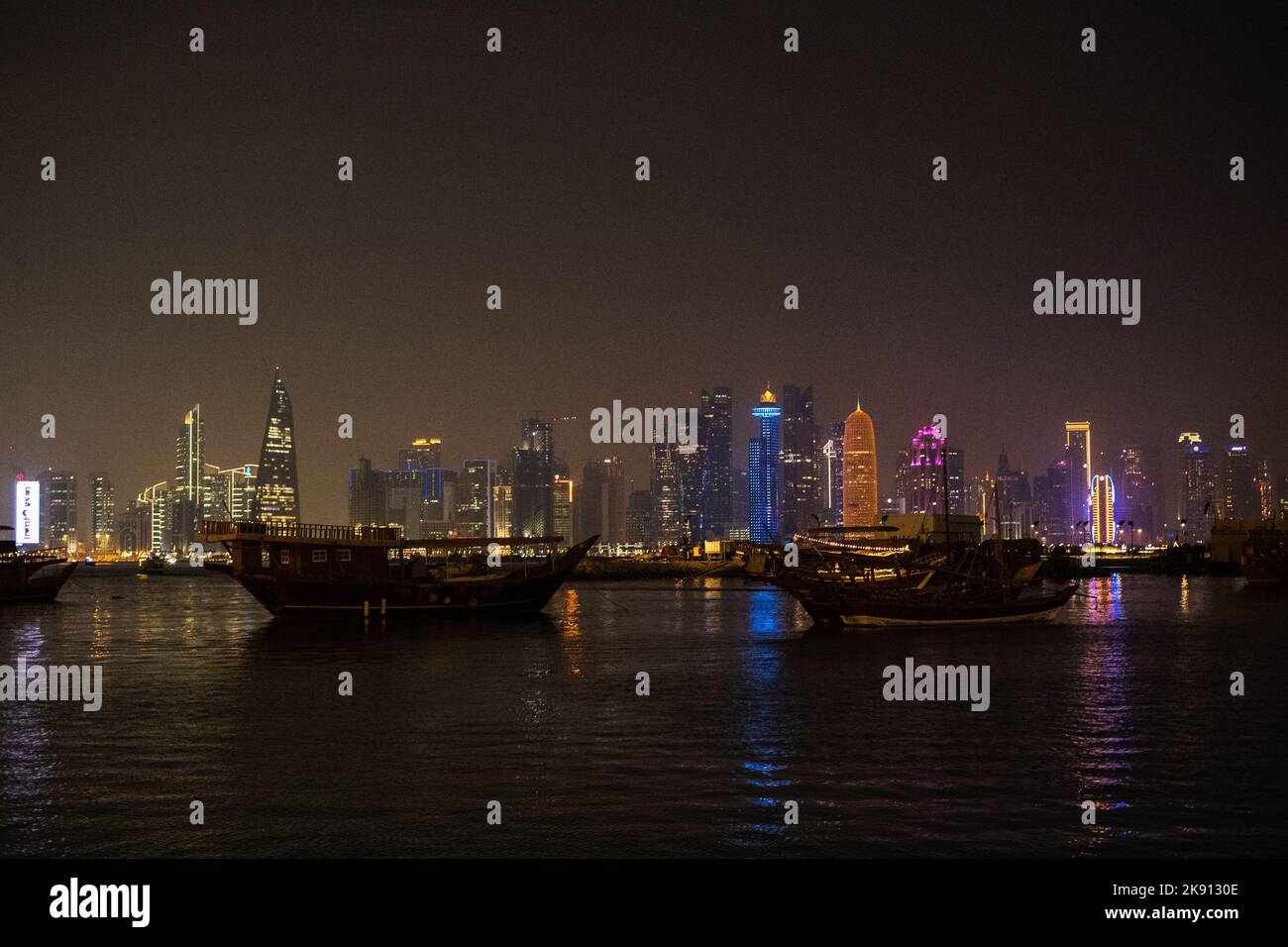 Slightly hazy Doha skyline at night, viewed across the water, from the ...