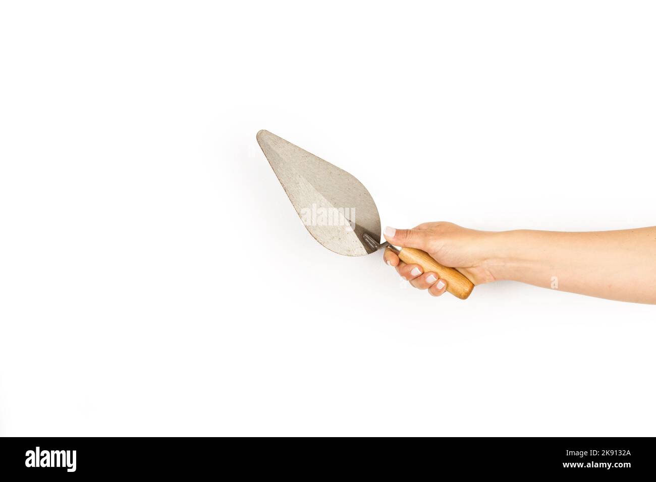 Woman hand holding a bricklayer trowel on a white background with copy ...