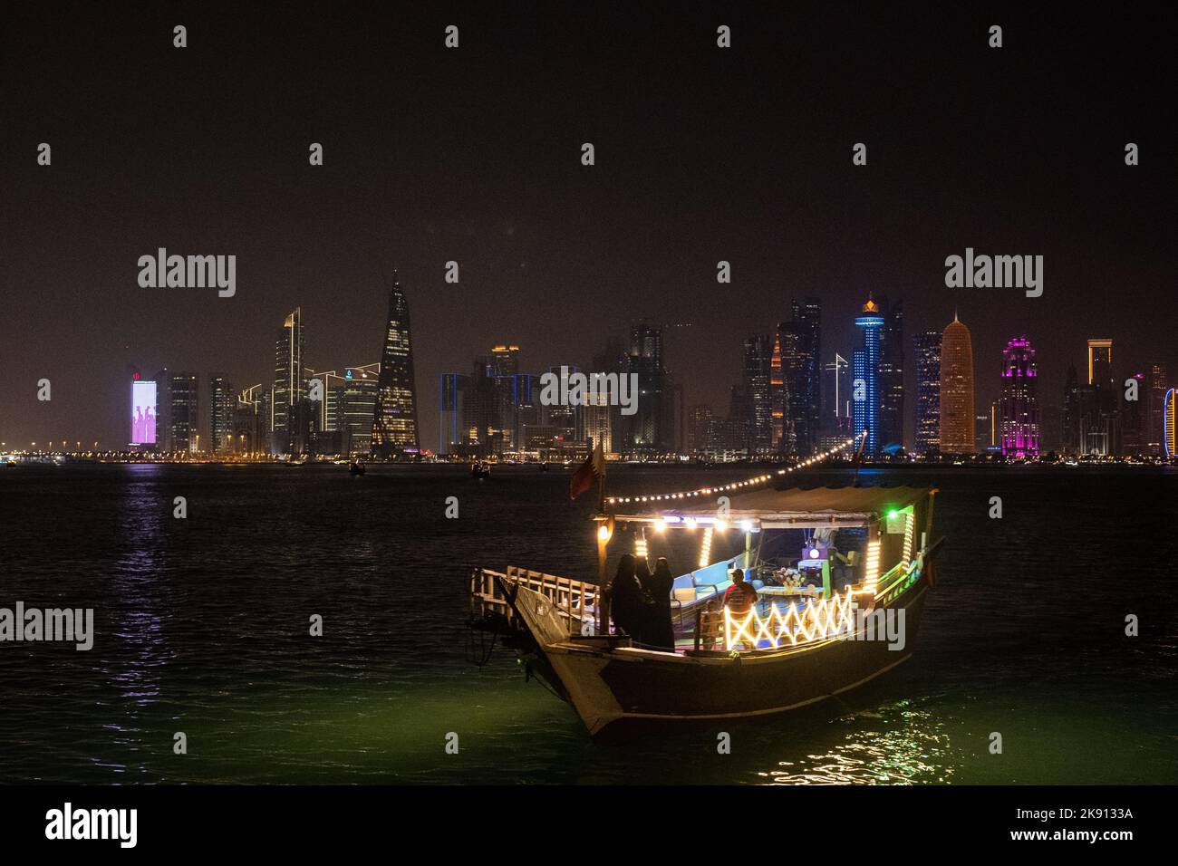 Slightly hazy Doha skyline at night, viewed across the water, from the ...