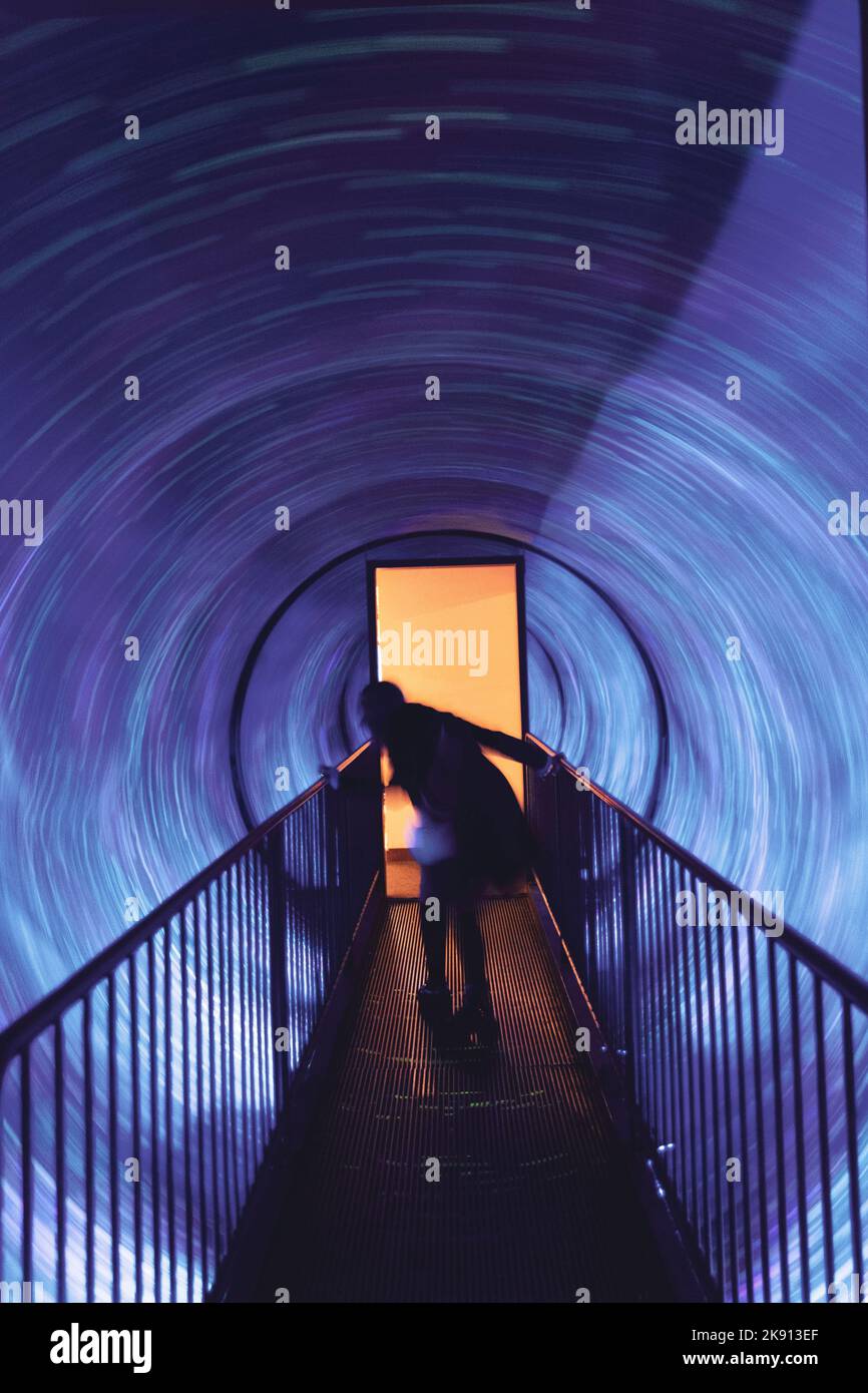 A vertical shot of a girl entering a black hole at the museum of ice ...