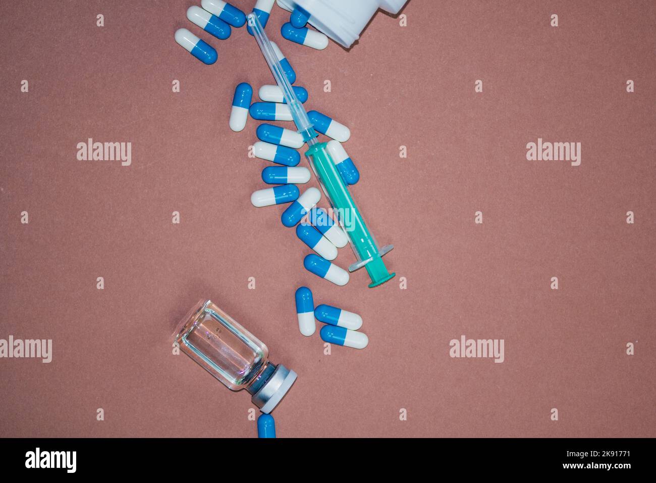 A top view of illegal doping injectable drug and capsules on a table ...