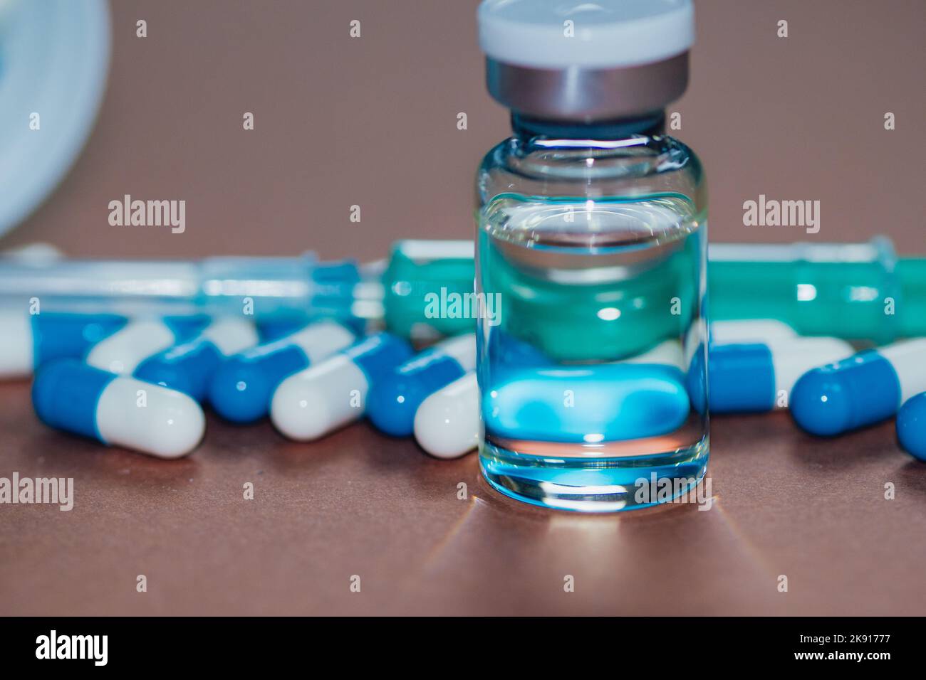 A closeup of illegal doping injectable drug and capsules on a table ...