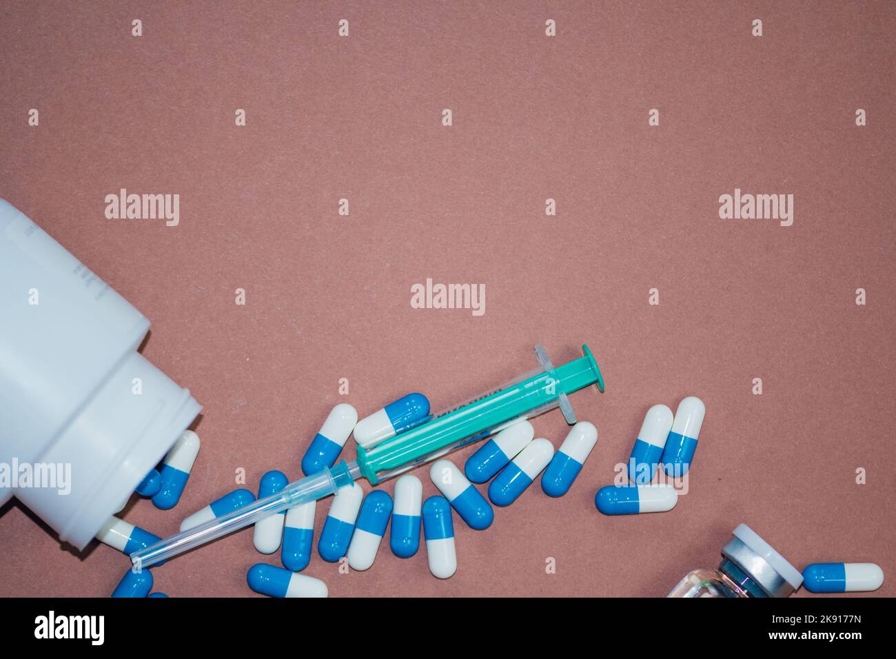 A top view of illegal doping injectable drug and capsules on a table ...