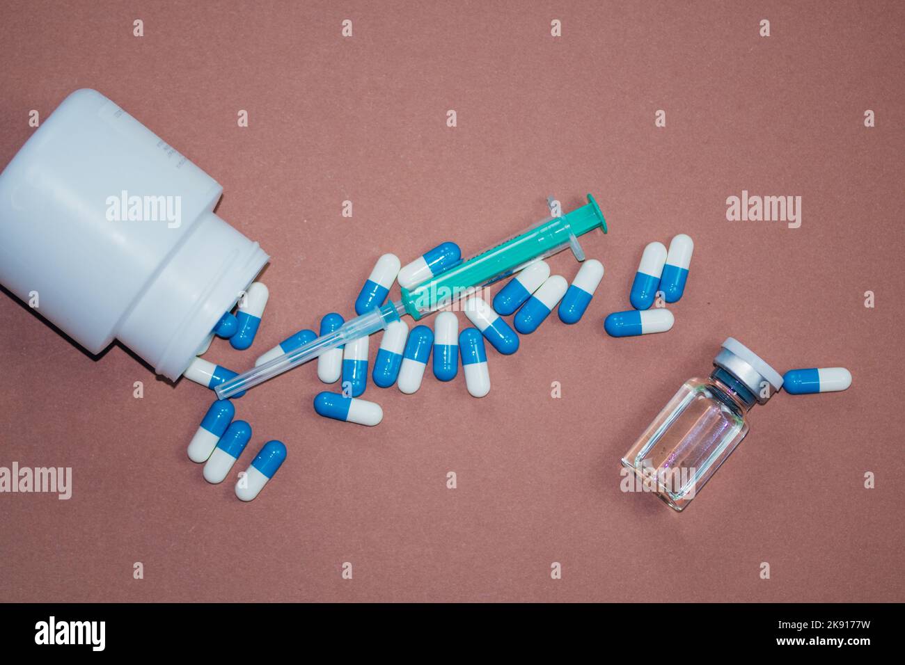 A top view of illegal doping injectable drug and capsules on a table ...