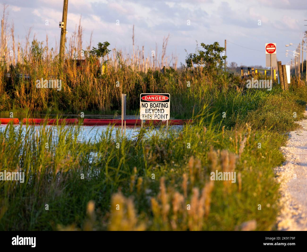 A warning sign in the lake surrounded by bushes Stock Photo - Alamy