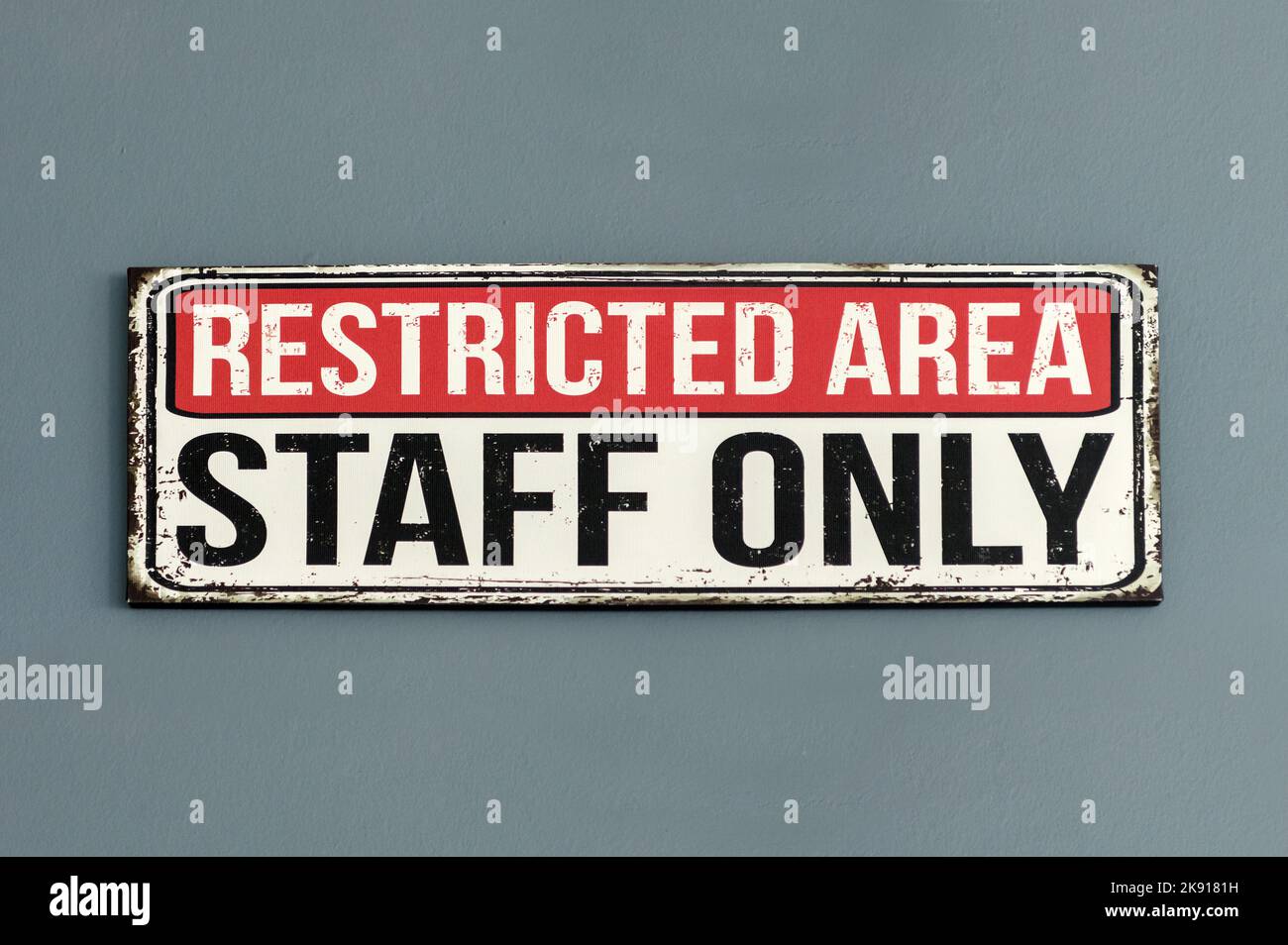 Simple metal plate saying Restricted Area Staff Only hanging on gray ...