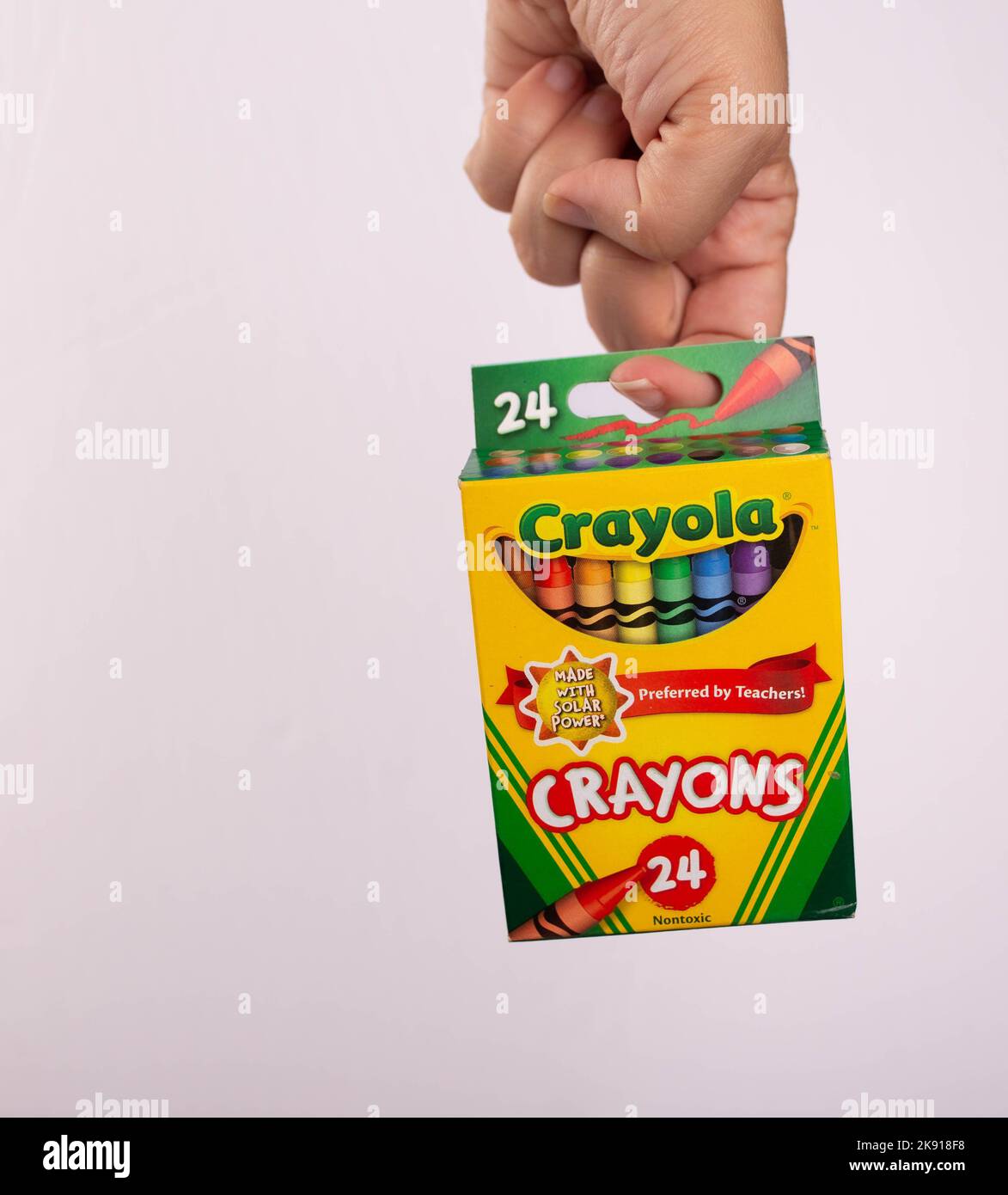 A hand holding a new box of colorful crayons from Crayola Stock Photo ...
