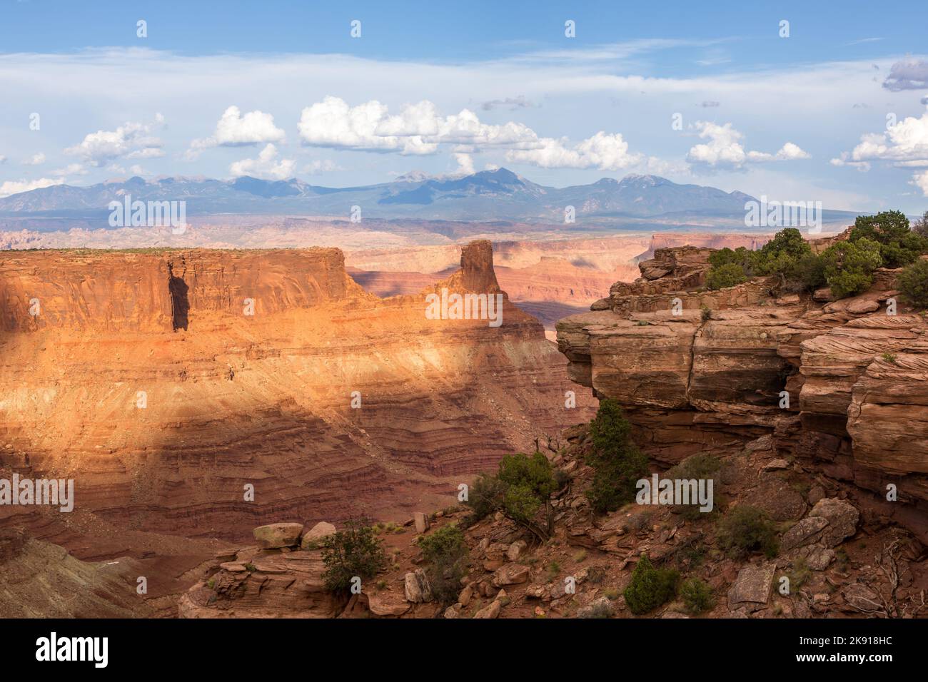 Spotlighting on a Wingate sandstone tower with the La Sal Mountains ...