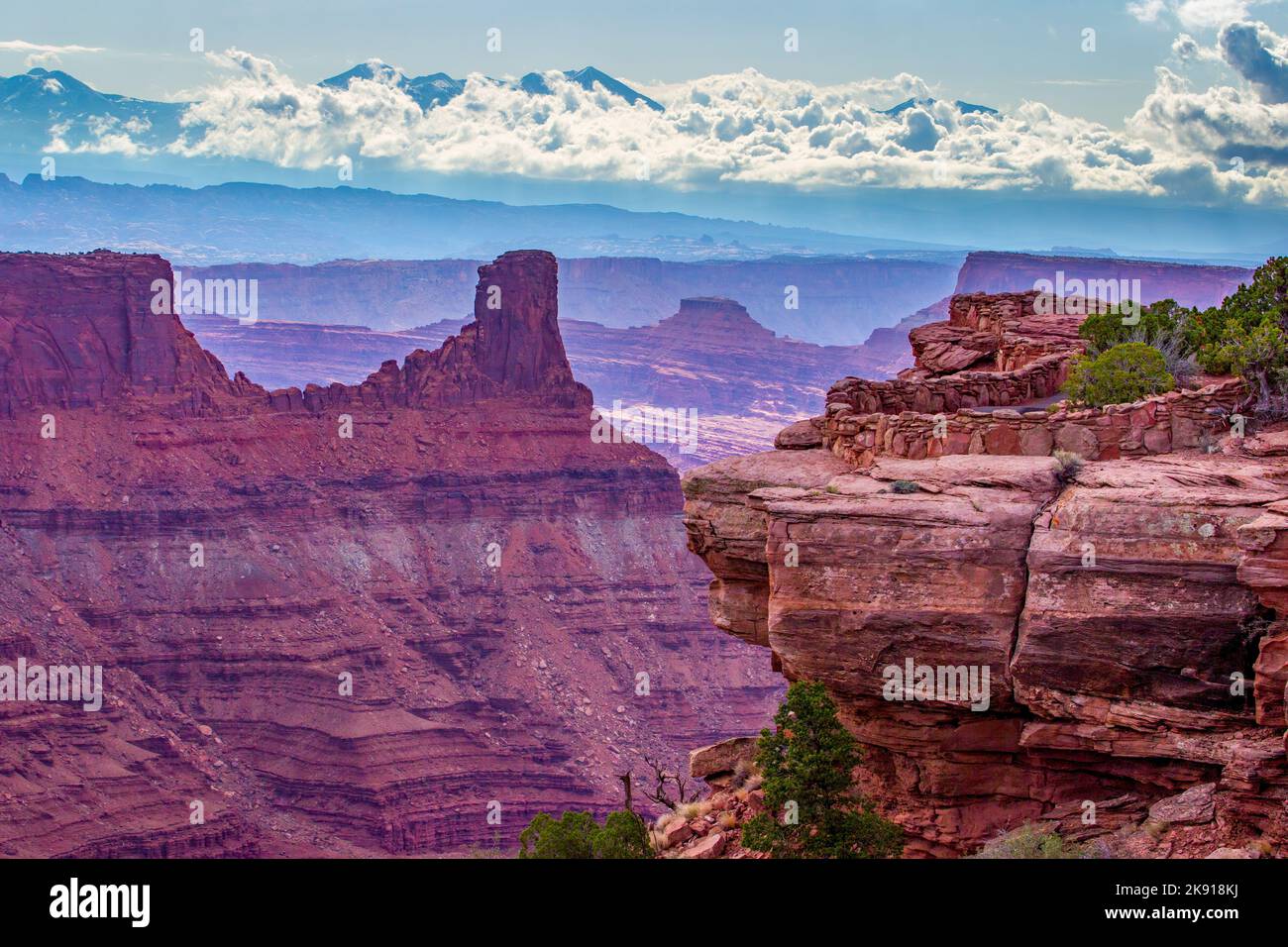 A Wingate sandstone tower in front of the La Sal Mountains with low ...