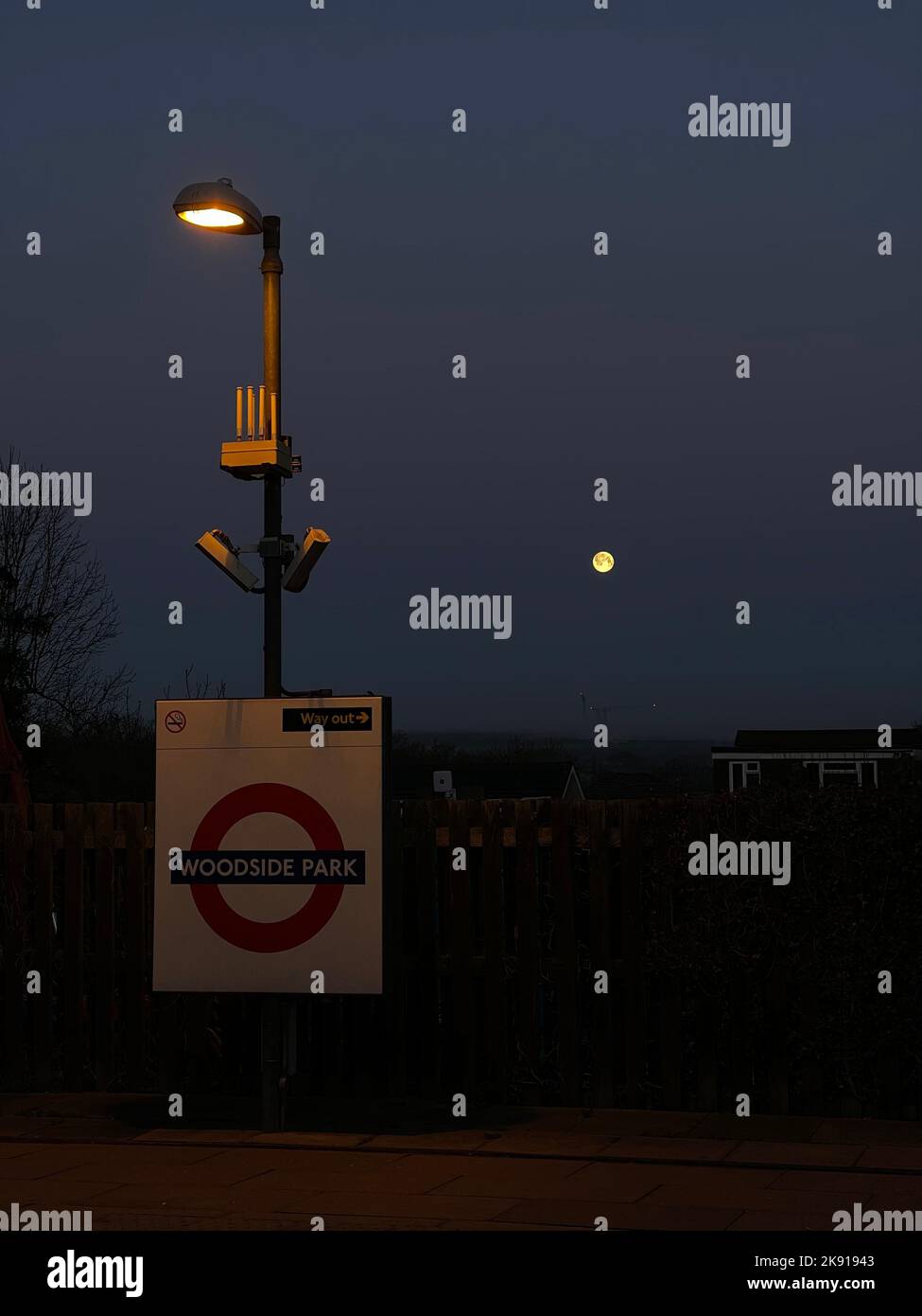 A vertical closeup of a street light with the "Underground" sign, night ...
