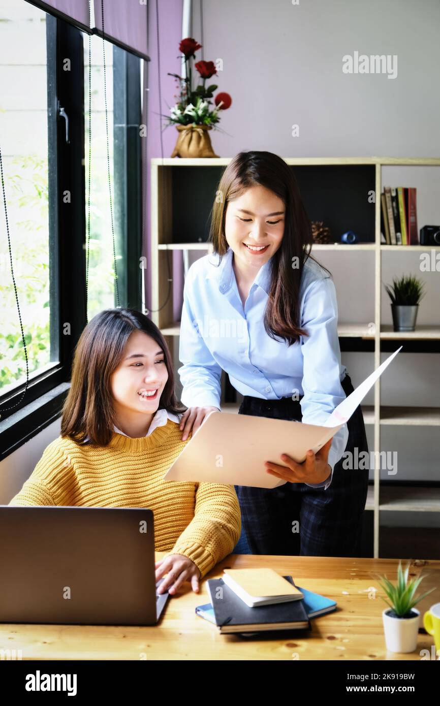 Two female company employees happily smiled at each other as they ...