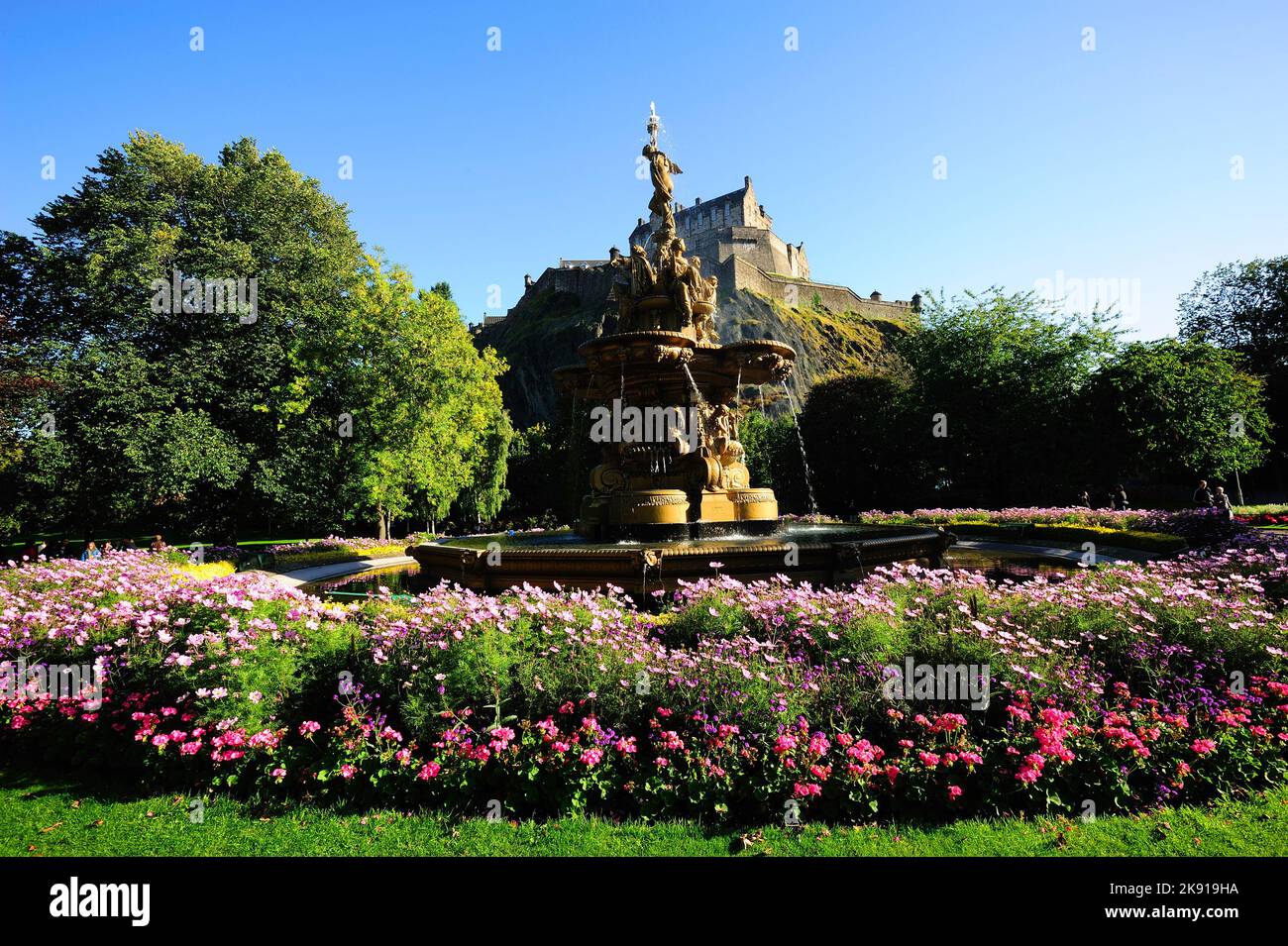 A beautiful old fountain in a green park with pink flowers in Edinburgh ...