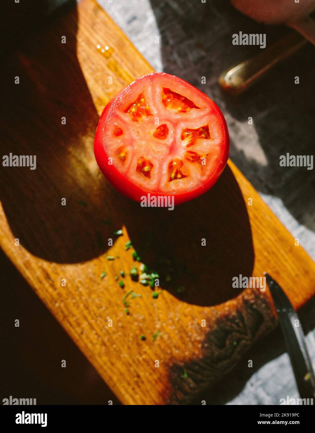 A top view of a tomato cross section on a wooden cutting board Stock ...