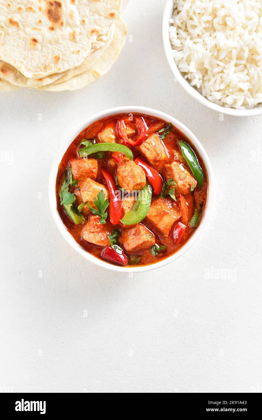 Thai style red chicken curry with vegetables in bowl over white ...