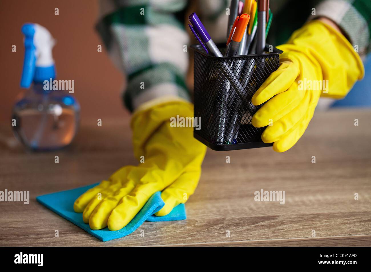Woman cleans office in the yellow gloves wipes the dust off the office ...