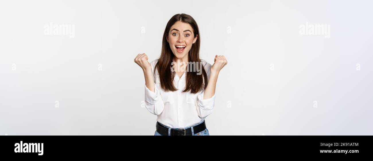 Excited young adult woman reacting to win, surprise news, screaming and ...