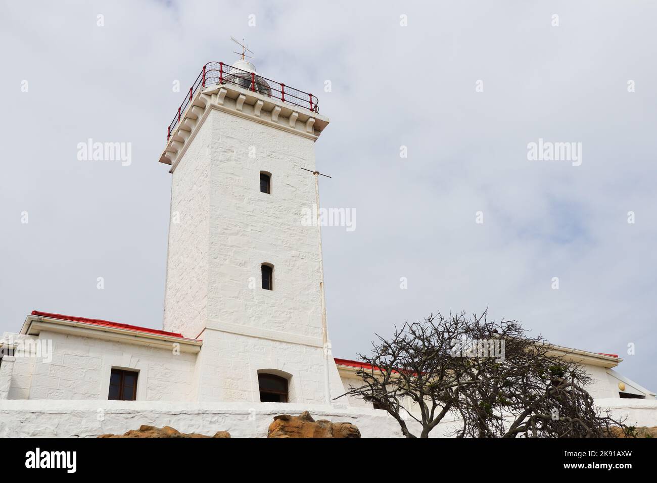 White Stone Lighthouse Tower With Overcast Sky Stock Photo - Alamy
