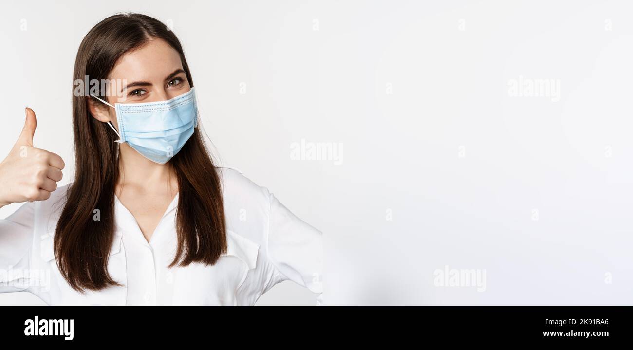 Close up portrait, face of woman in medical mask smiling, showing ...
