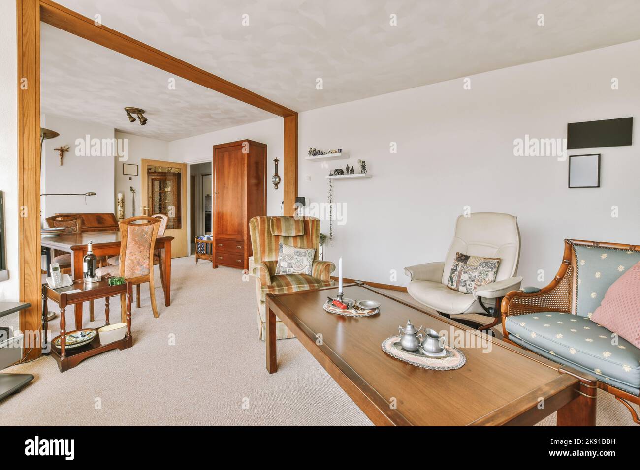 Wooden table with vase and chairs placed near opened balcony door in ...