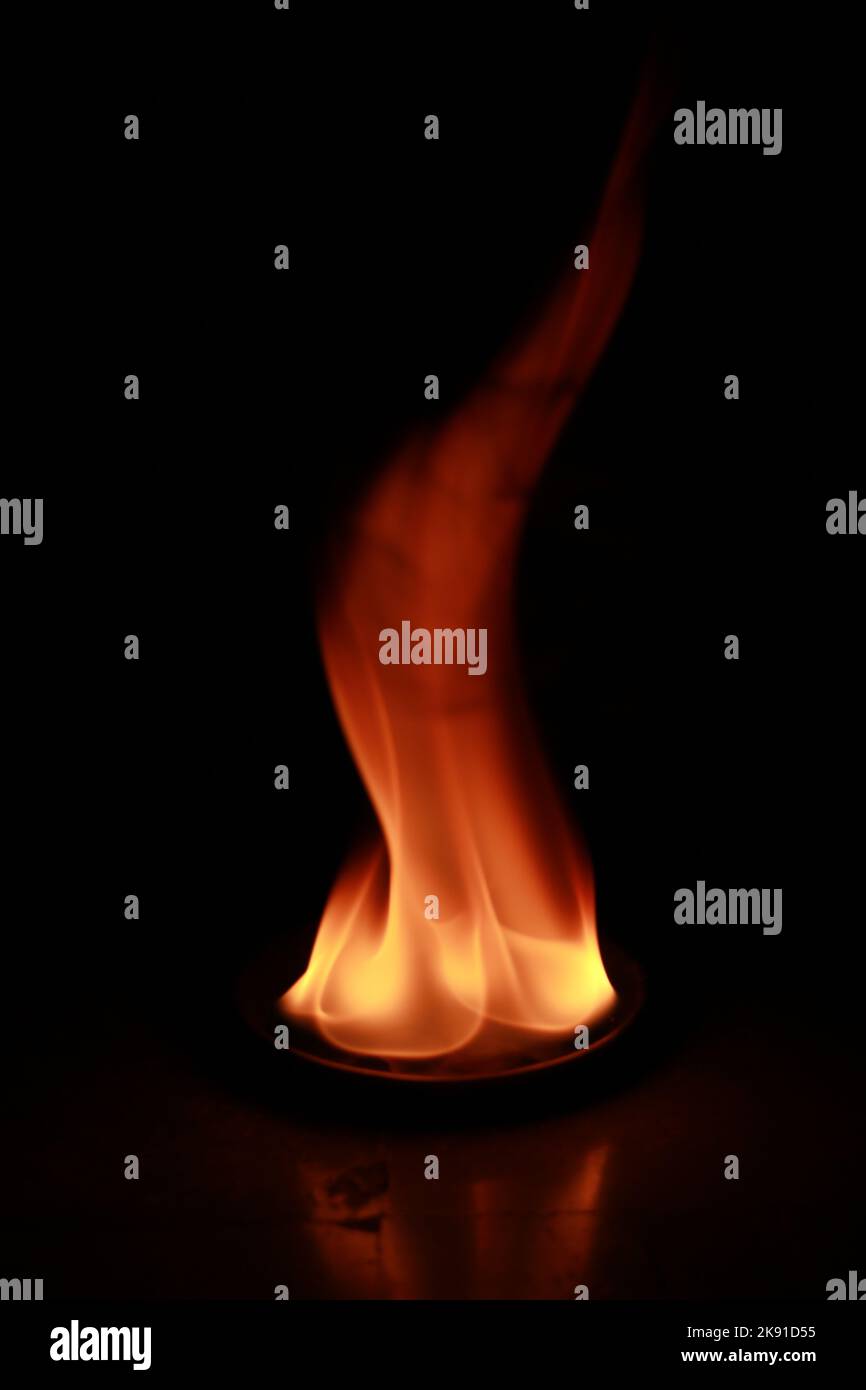 A vertical closeup illustration of a camphor flame on the dark ...