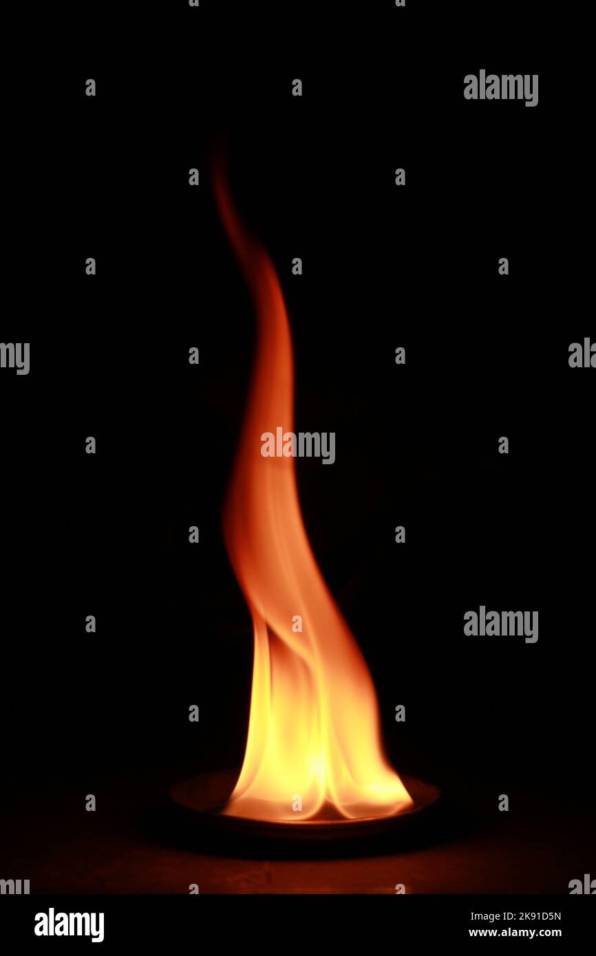 A vertical closeup illustration of a camphor flame on the dark ...
