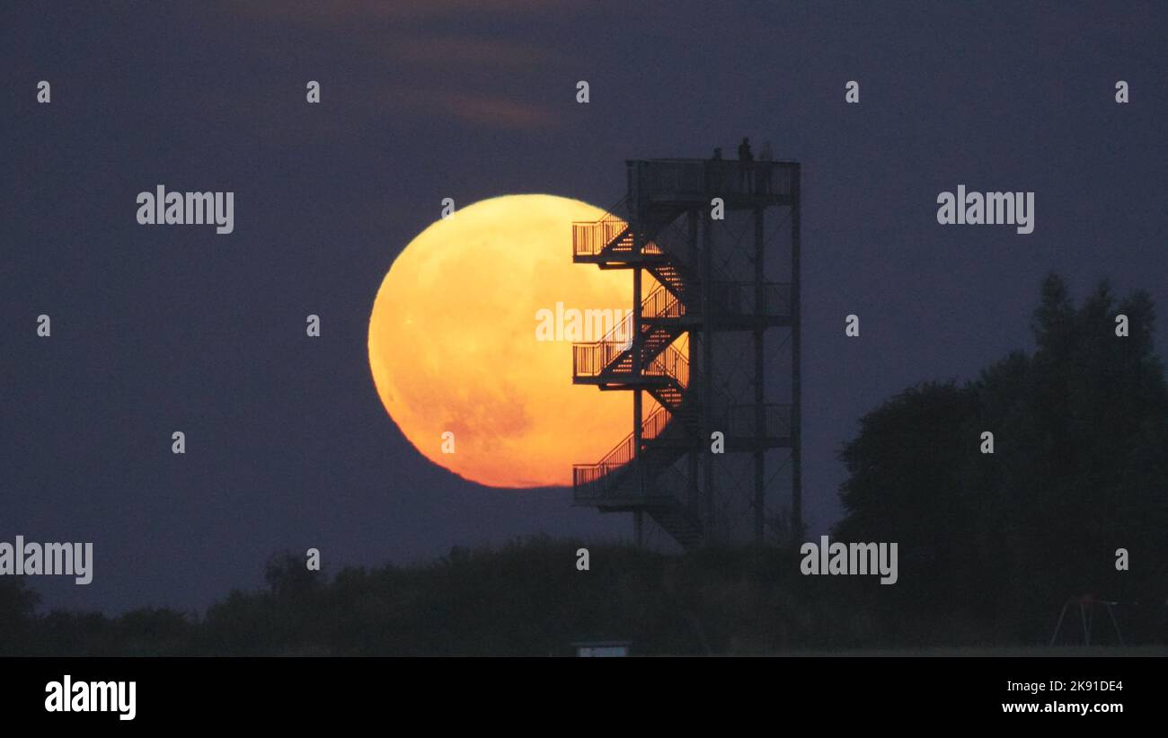 Silhouetted onlookers watching the moon from the observation tower in ...