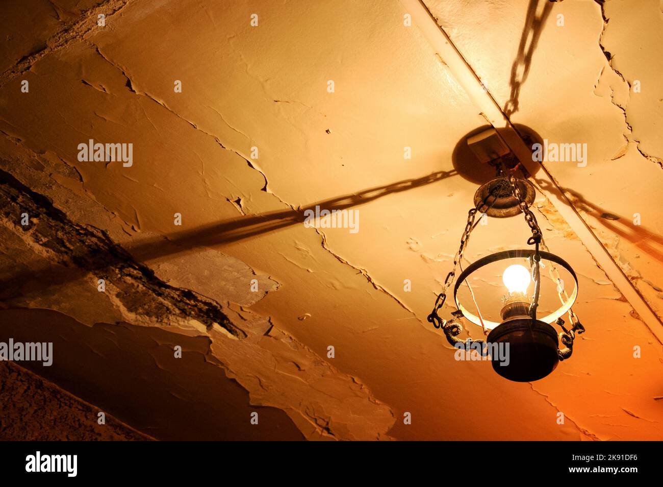 Old lamp hanging from damaged ceiling. Decay, poverty concepts Stock ...