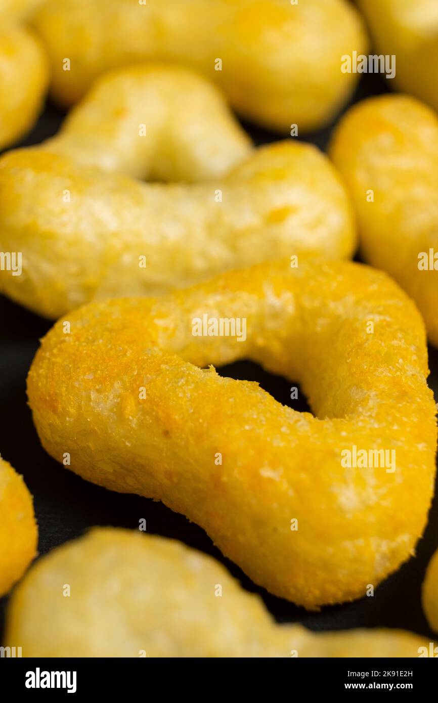 Delicious crispy corn chips triangular shape with spices on a black ...