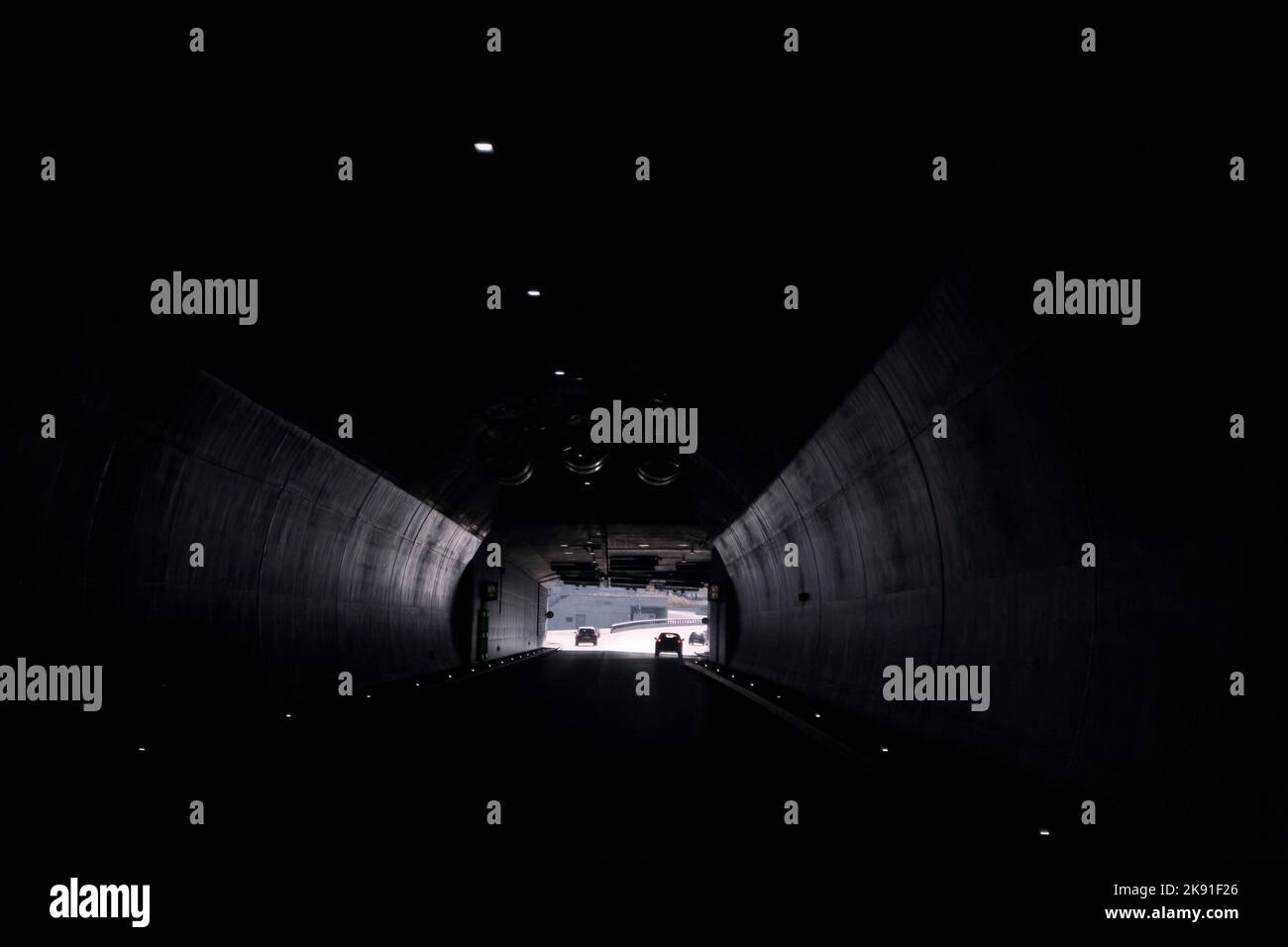 Dark underground tunnel with road and light at the end hi-res stock ...