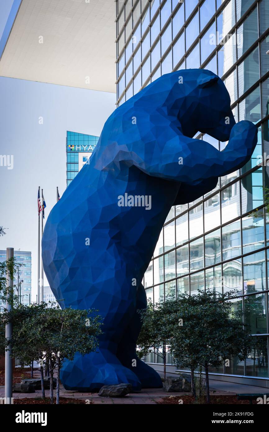 A statue of a big blue bear looking through the windows at the ...