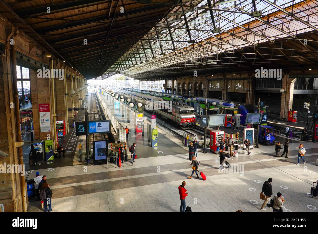 Trains at platforms as travelers walk through station Gare du Nord, the ...