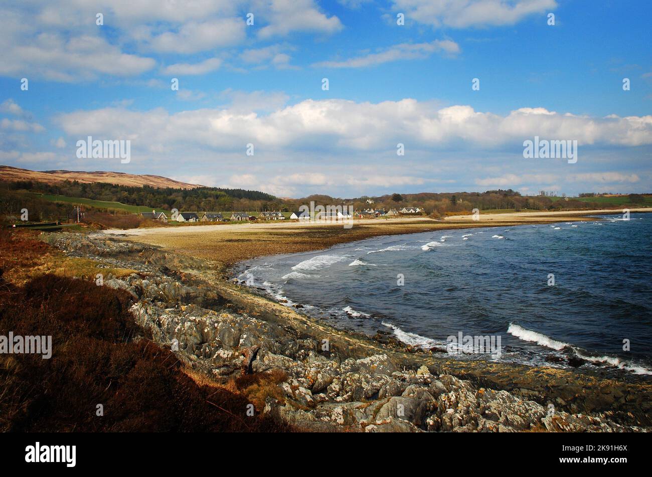 A scenic view of rural houses on the beach against sea waves in ...