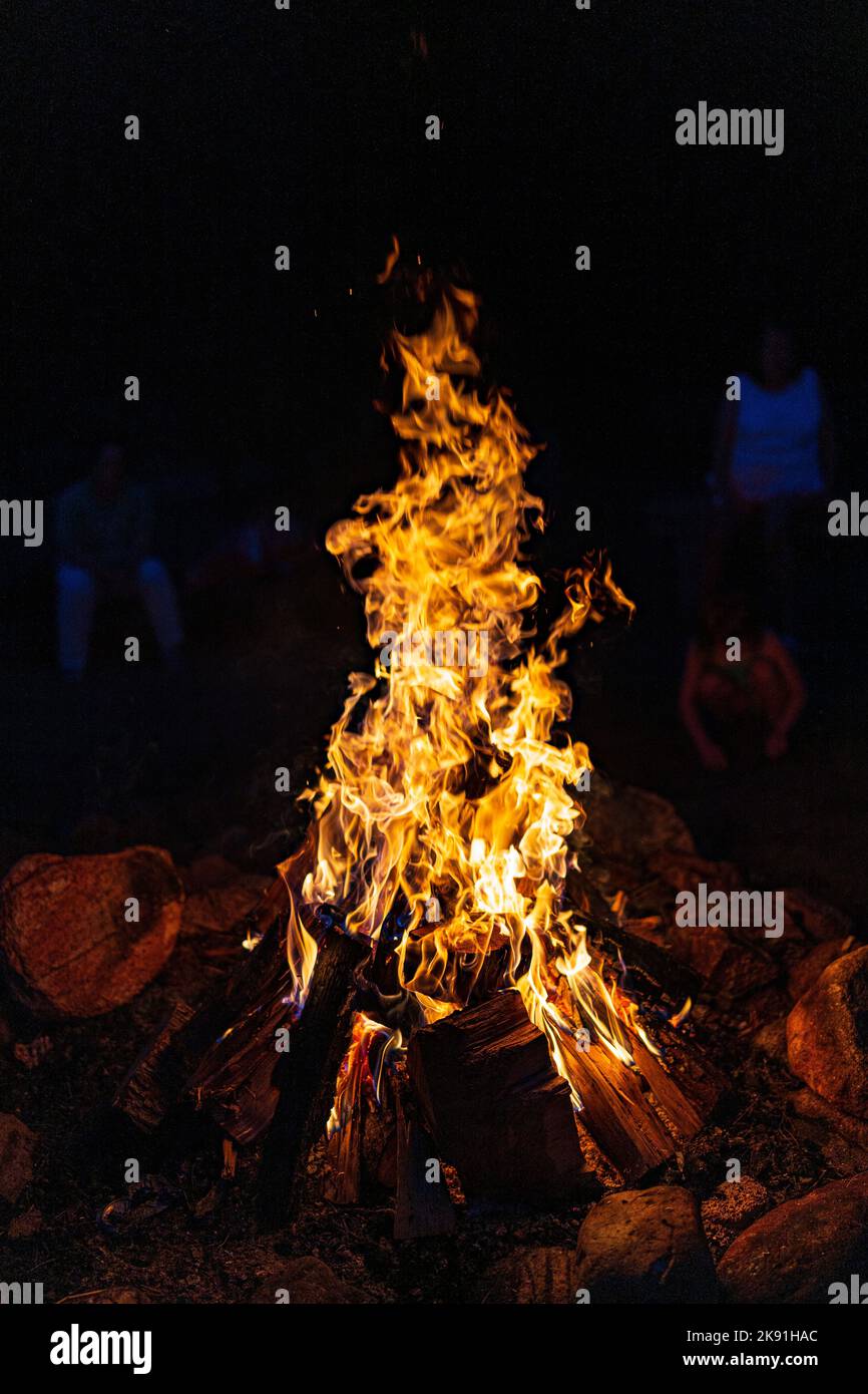 A beautiful shot of a bonfire with people in the background Stock Photo ...
