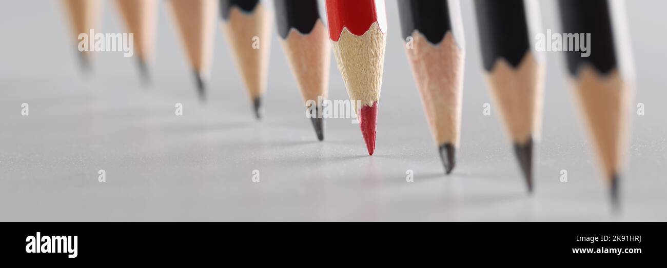 Tips of pencils put on paper in strict order, unique red among ordinary ...