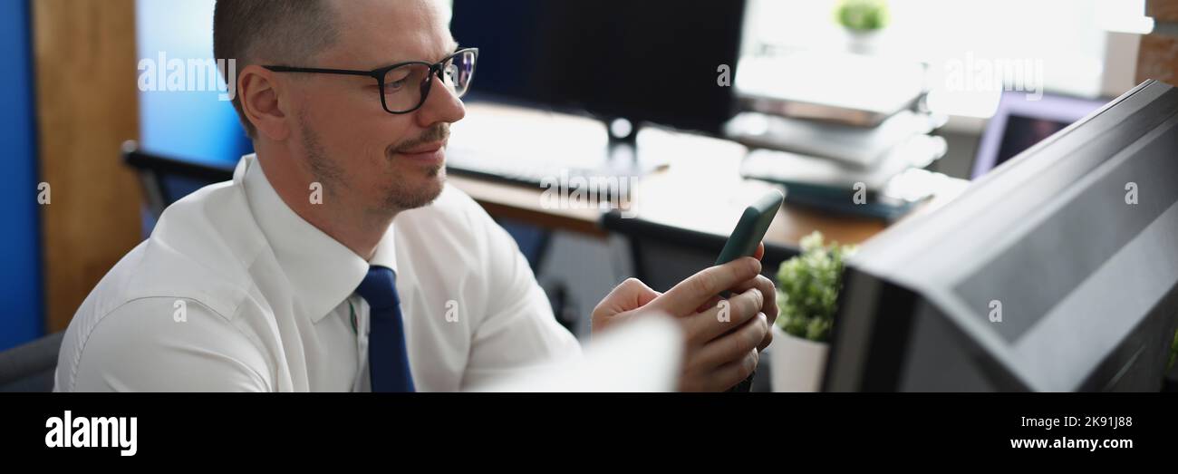 Businessman texting on smartphone, worker alone on workplace in office ...