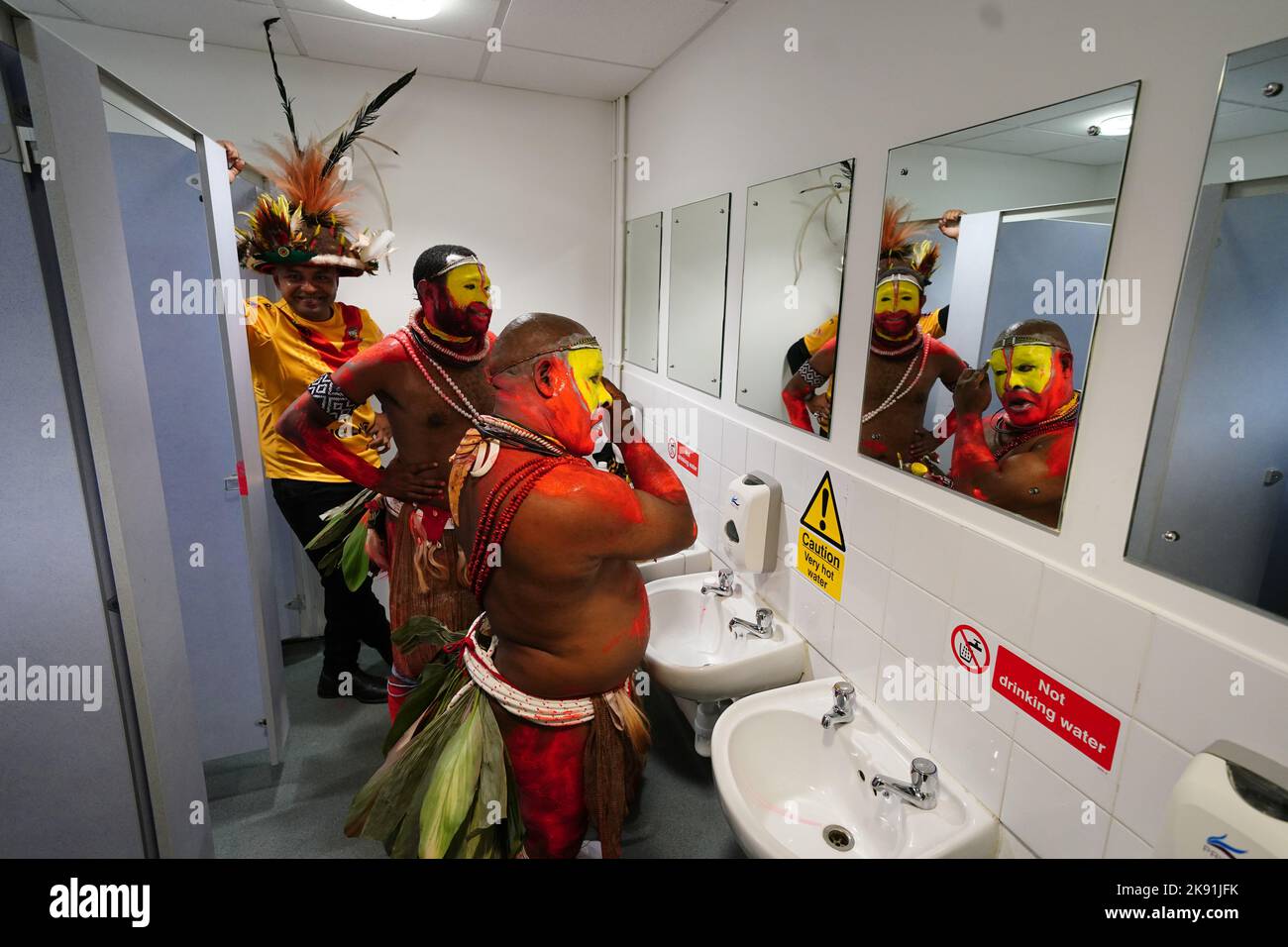 Papau New Guinea fans apply face paint in the toilets ahead of the ...