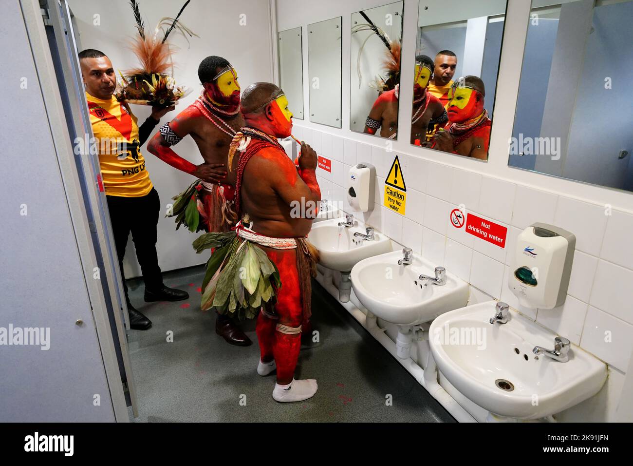 Papau New Guinea fans apply face paint in the toilets ahead of the ...
