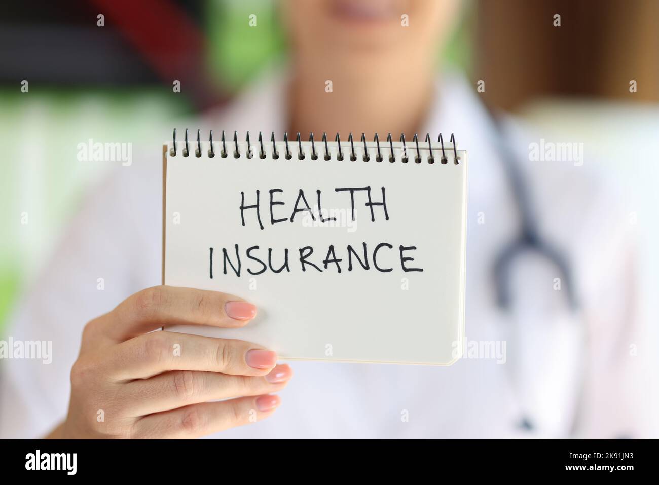 Female hand holding notepad with health insurance lettering Stock Photo ...