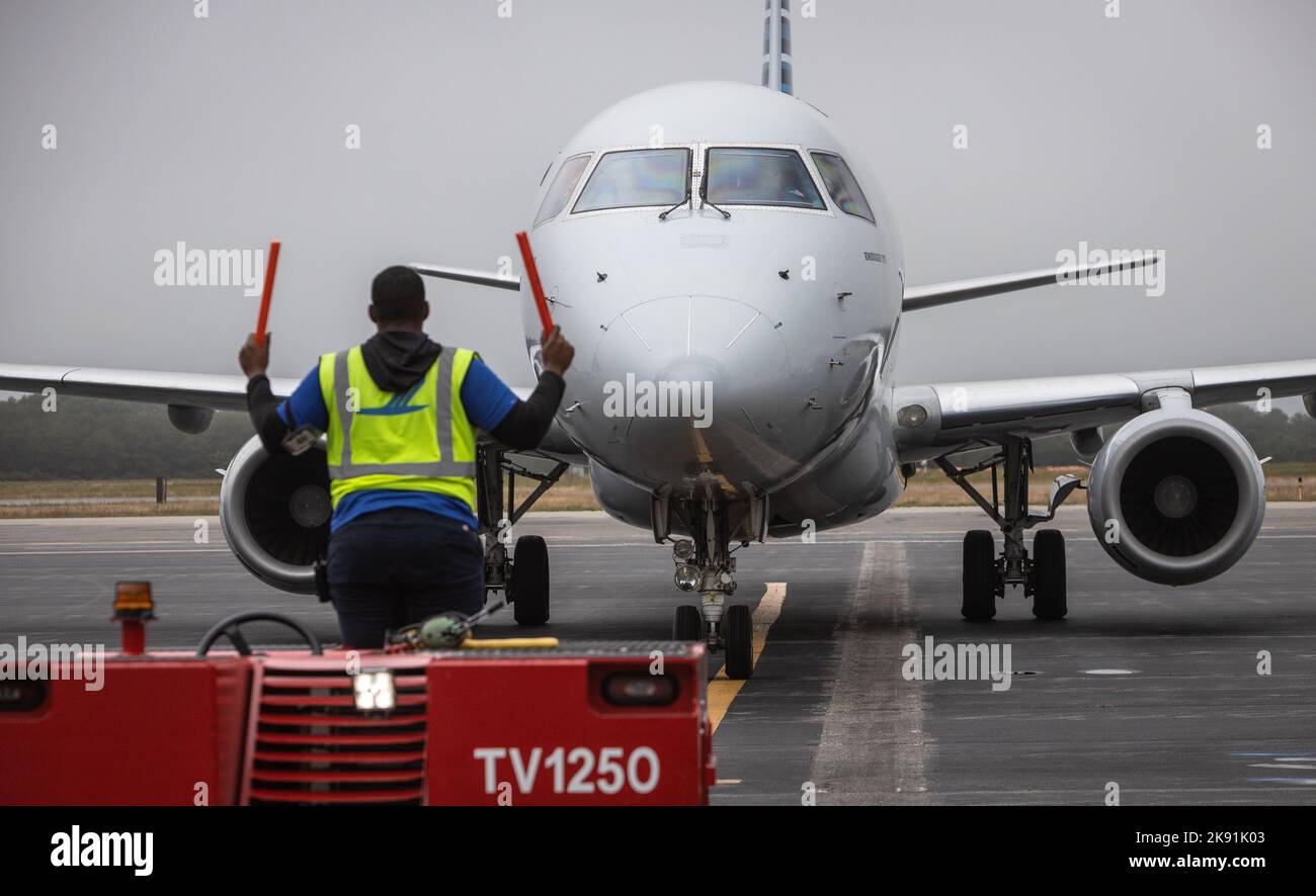 A man guiding an American Airlines plane into its parking spot at the ...