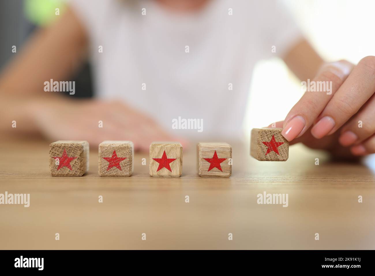 Female hand holding wooden cube with red star Stock Photo - Alamy