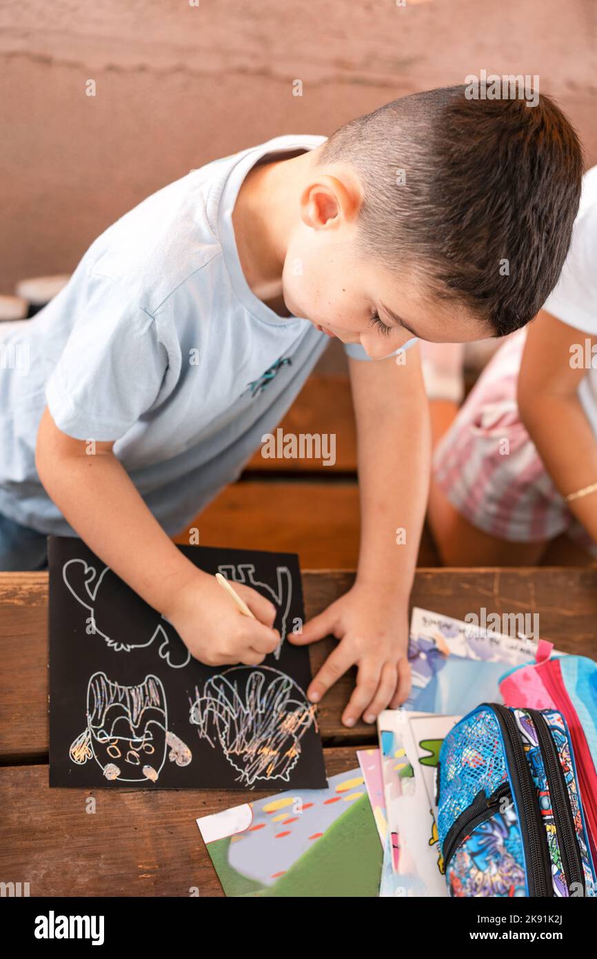 Little child draws scratches at a school yard Stock Photo - Alamy