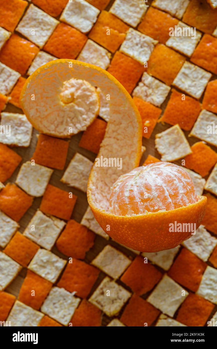 mandarin orange peeled in half on the peel in squares Stock Photo - Alamy